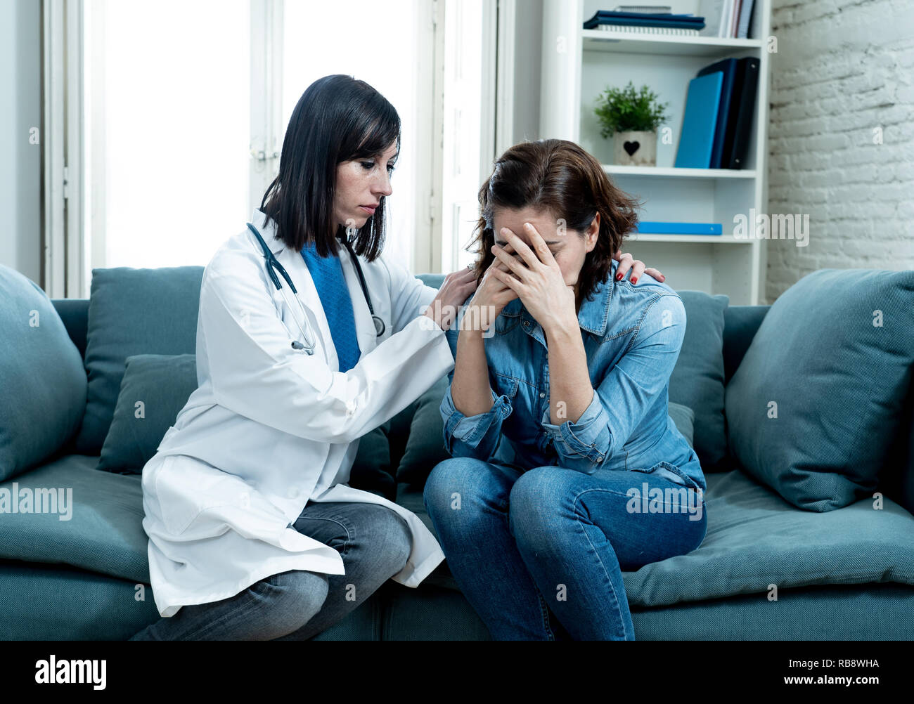 Female doctor comforting depressed crying woman patient sitting ...