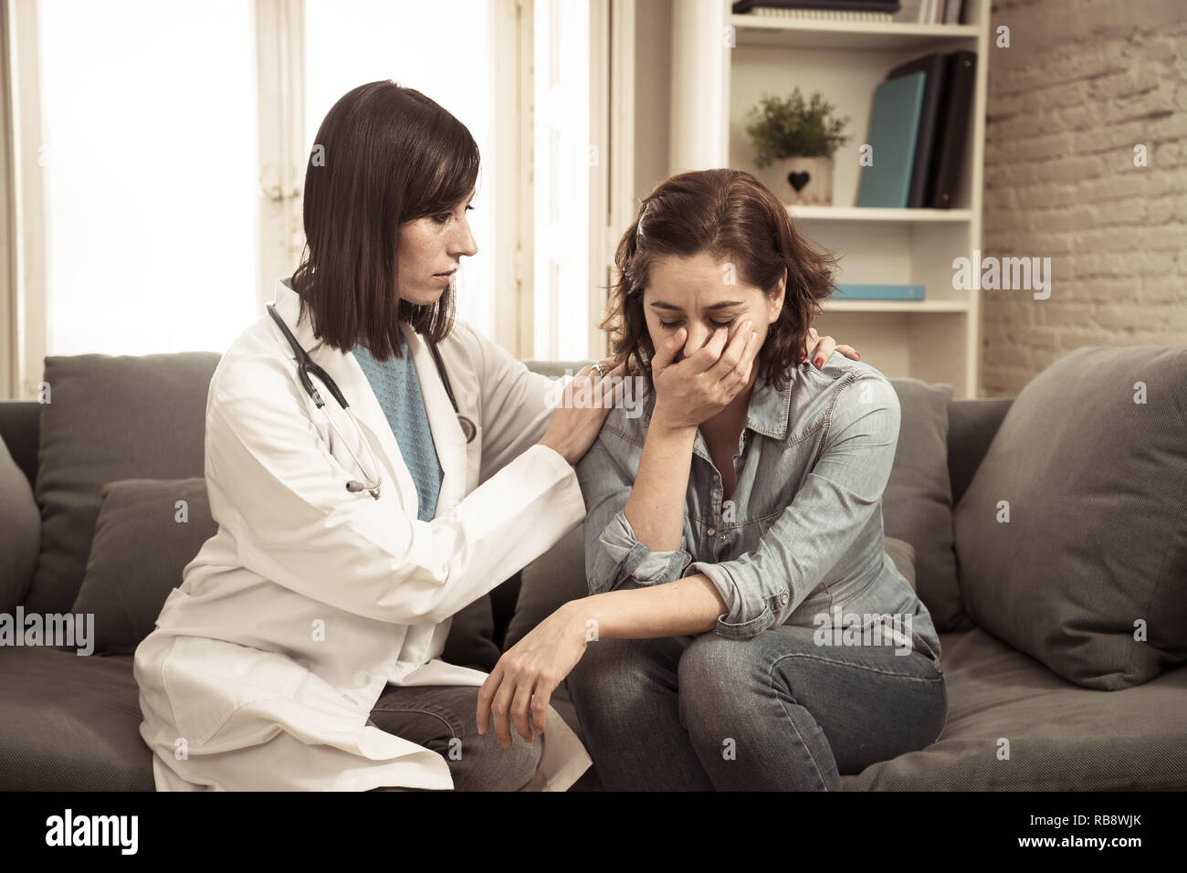 Female doctor comforting depressed crying woman patient sitting ...