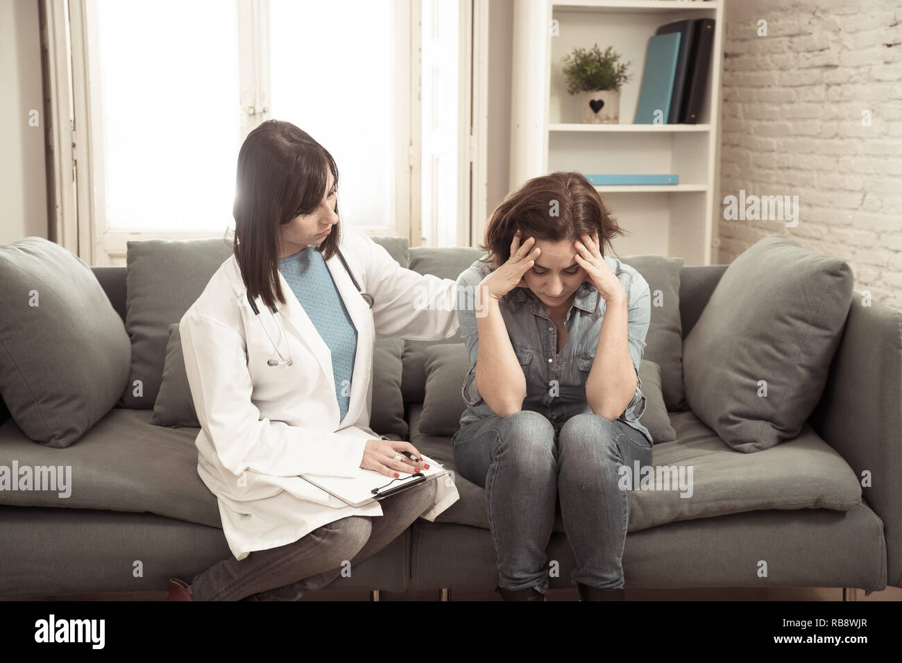 Female doctor comforting depressed crying woman patient sitting ...