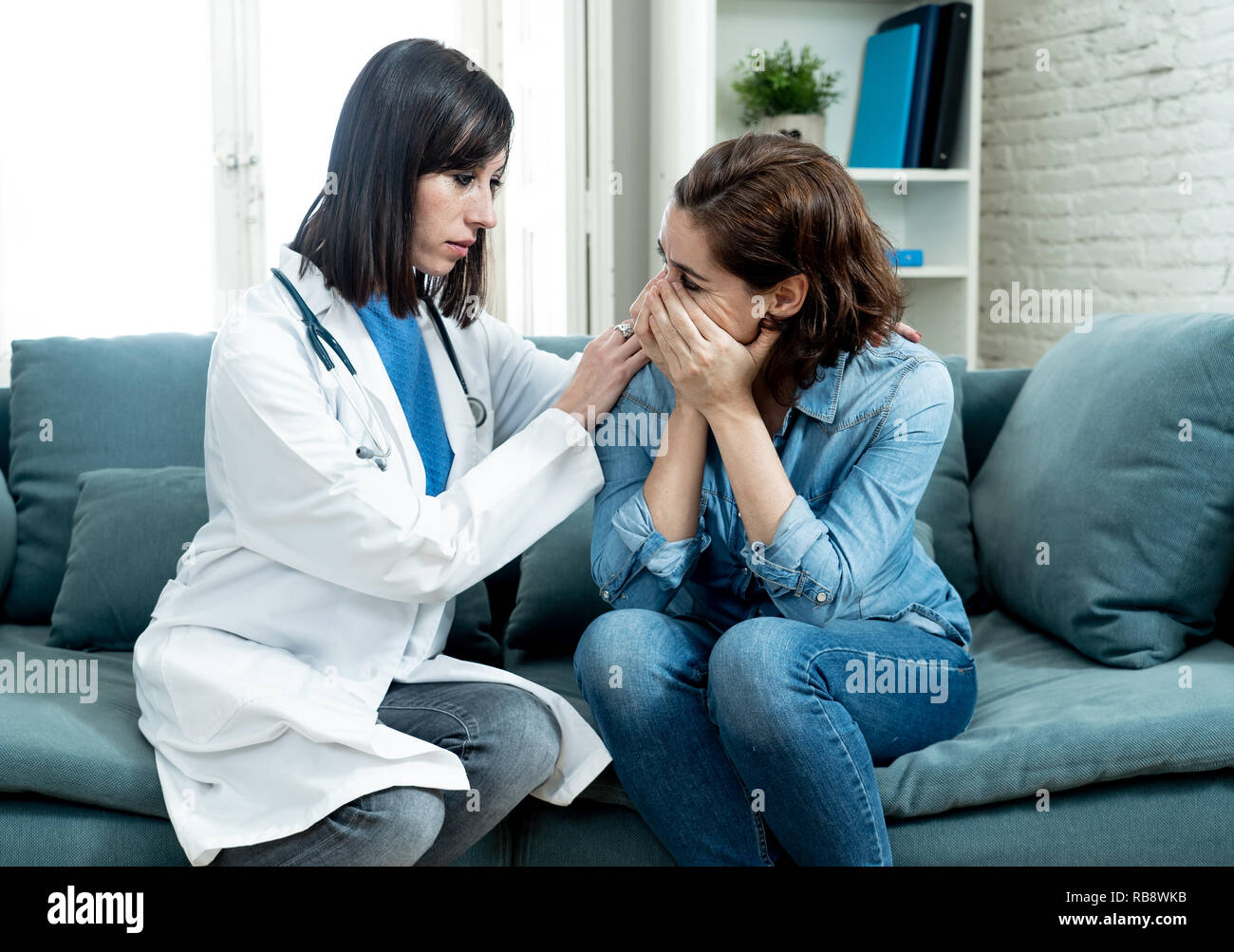 Female doctor comforting depressed crying woman patient sitting ...