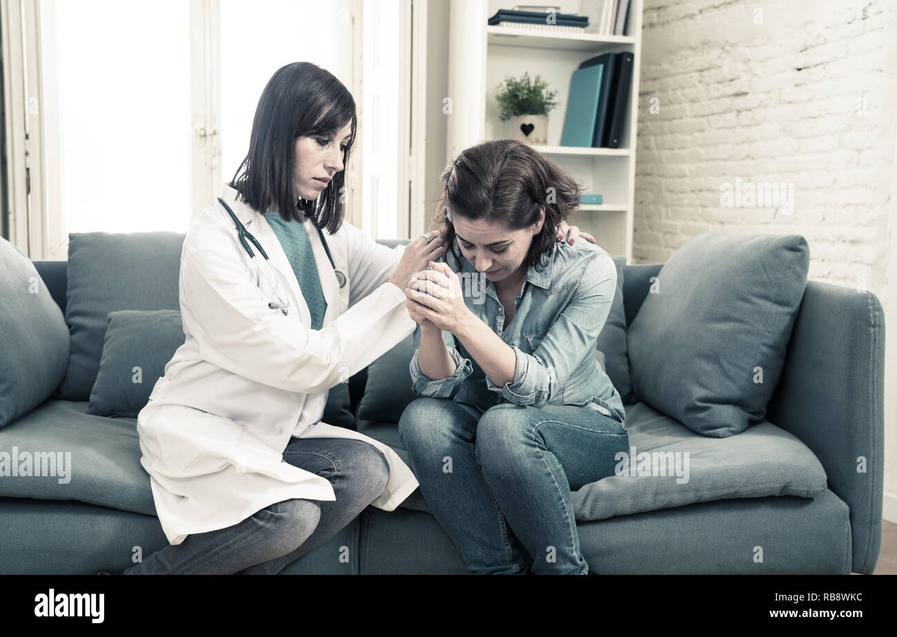 Female doctor comforting depressed crying woman patient sitting ...
