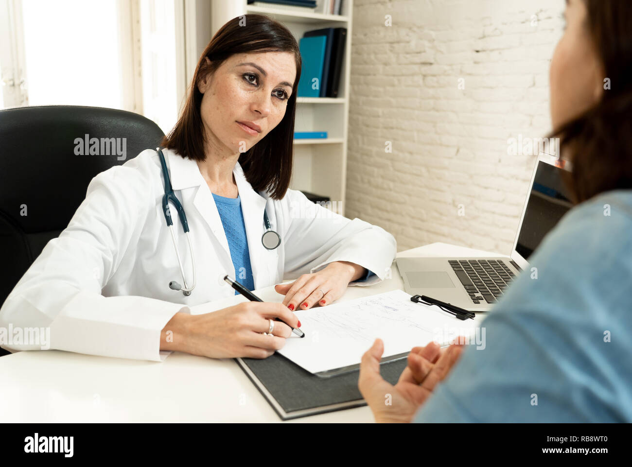 Female family doctor listening carefully to woman patient problems and ...