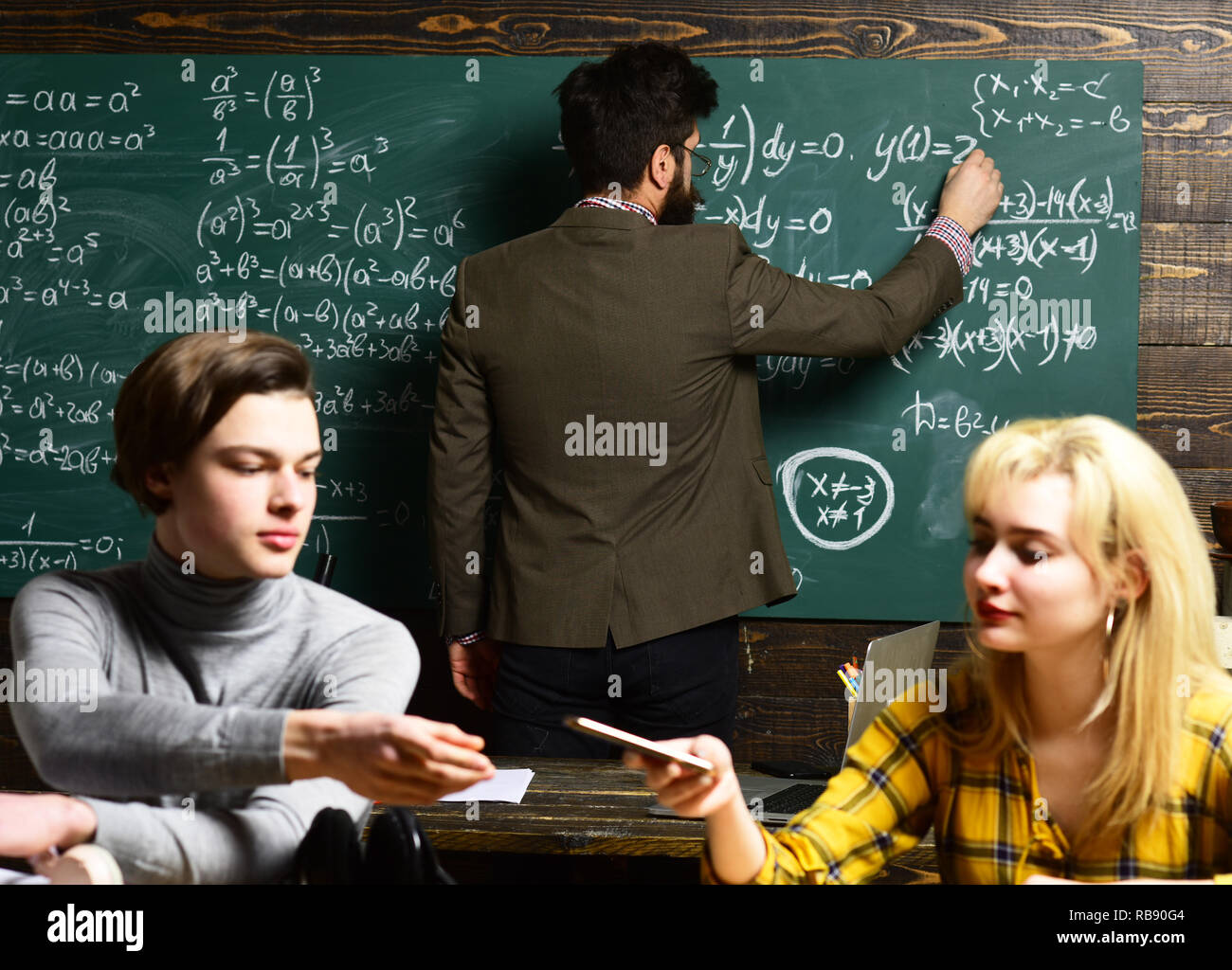 Teacher in glasses reading reports of talented students correcting ...
