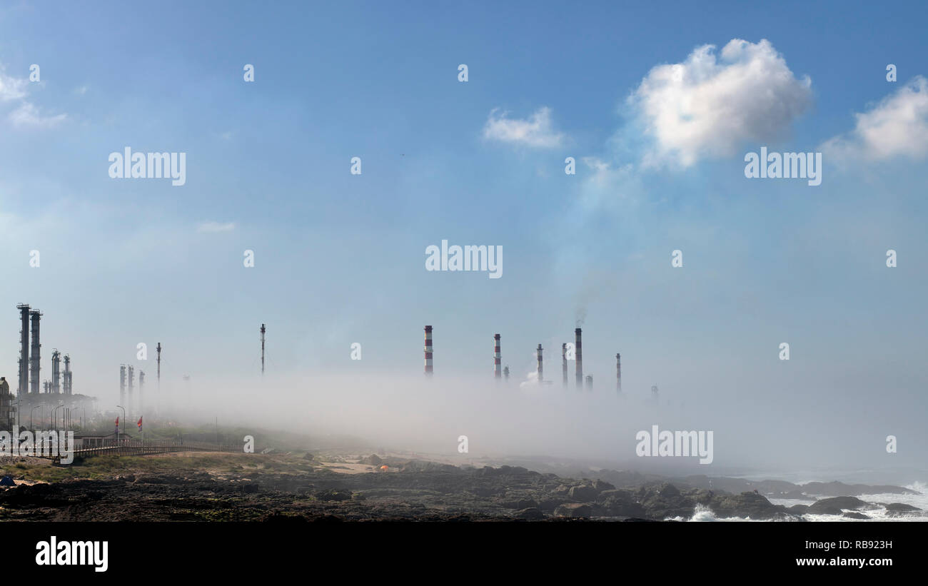 Big oil refinery near the sea and rocky beach seeing smog Stock Photo ...