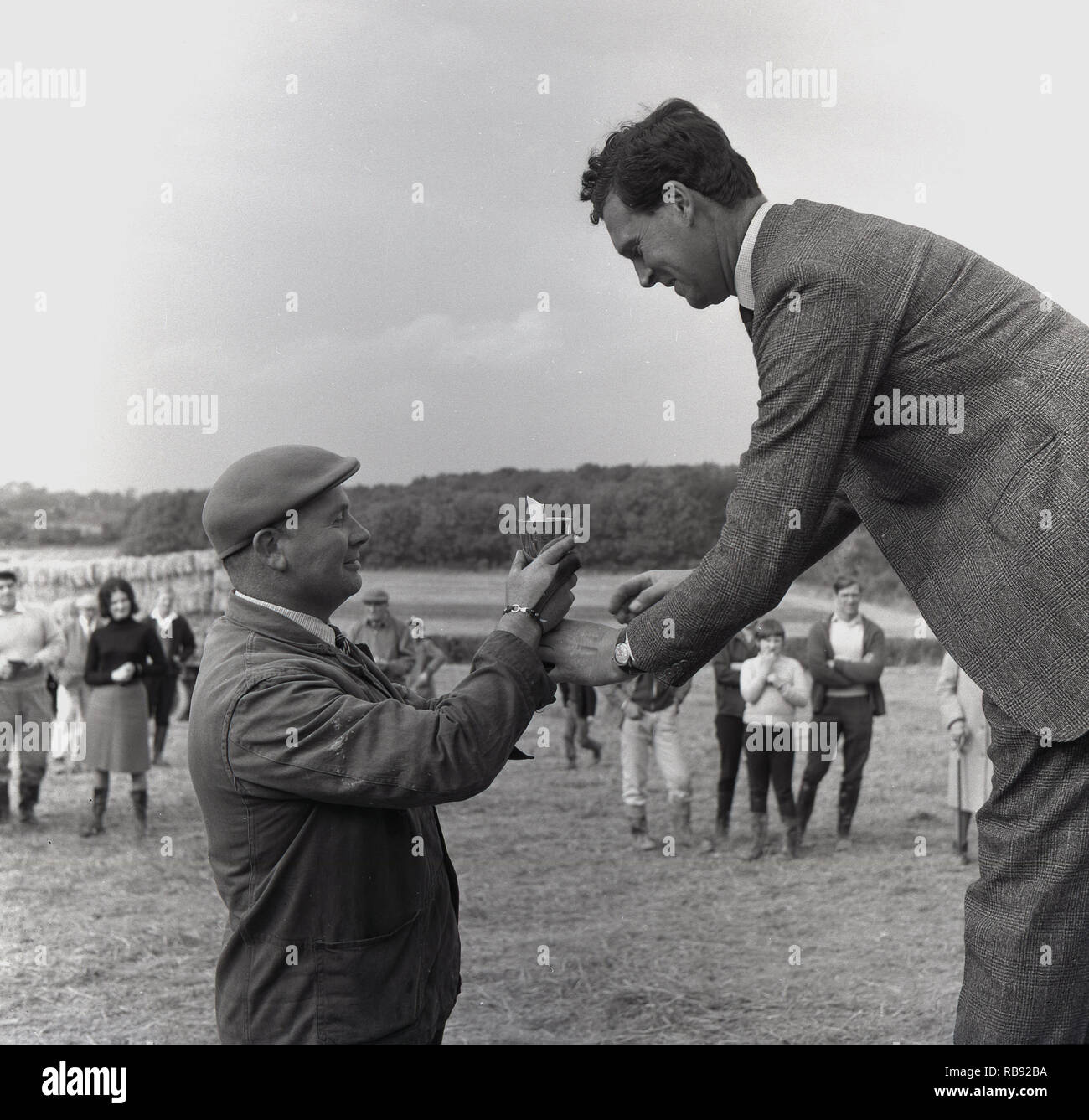 1965, historical, spectators look on as a farmer holds his trophy ...