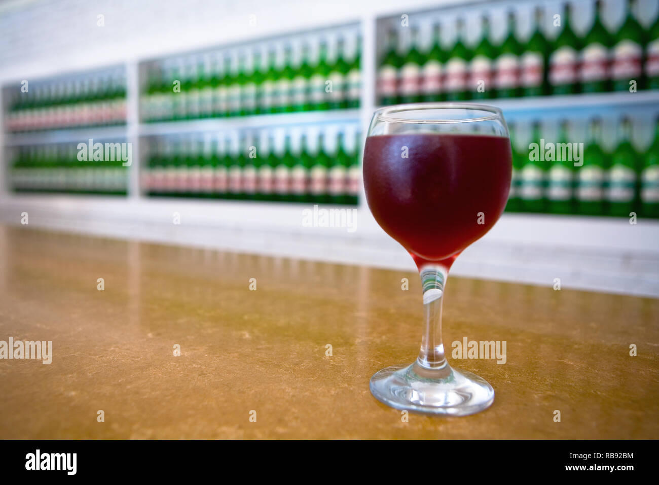 Cold wine in a glass on the background of bottles. Bar rack Stock Photo ...