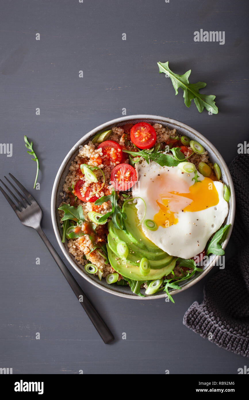 quinoa bowl with fried egg, avocado, tomato, rocket. Healthy vegetarian ...