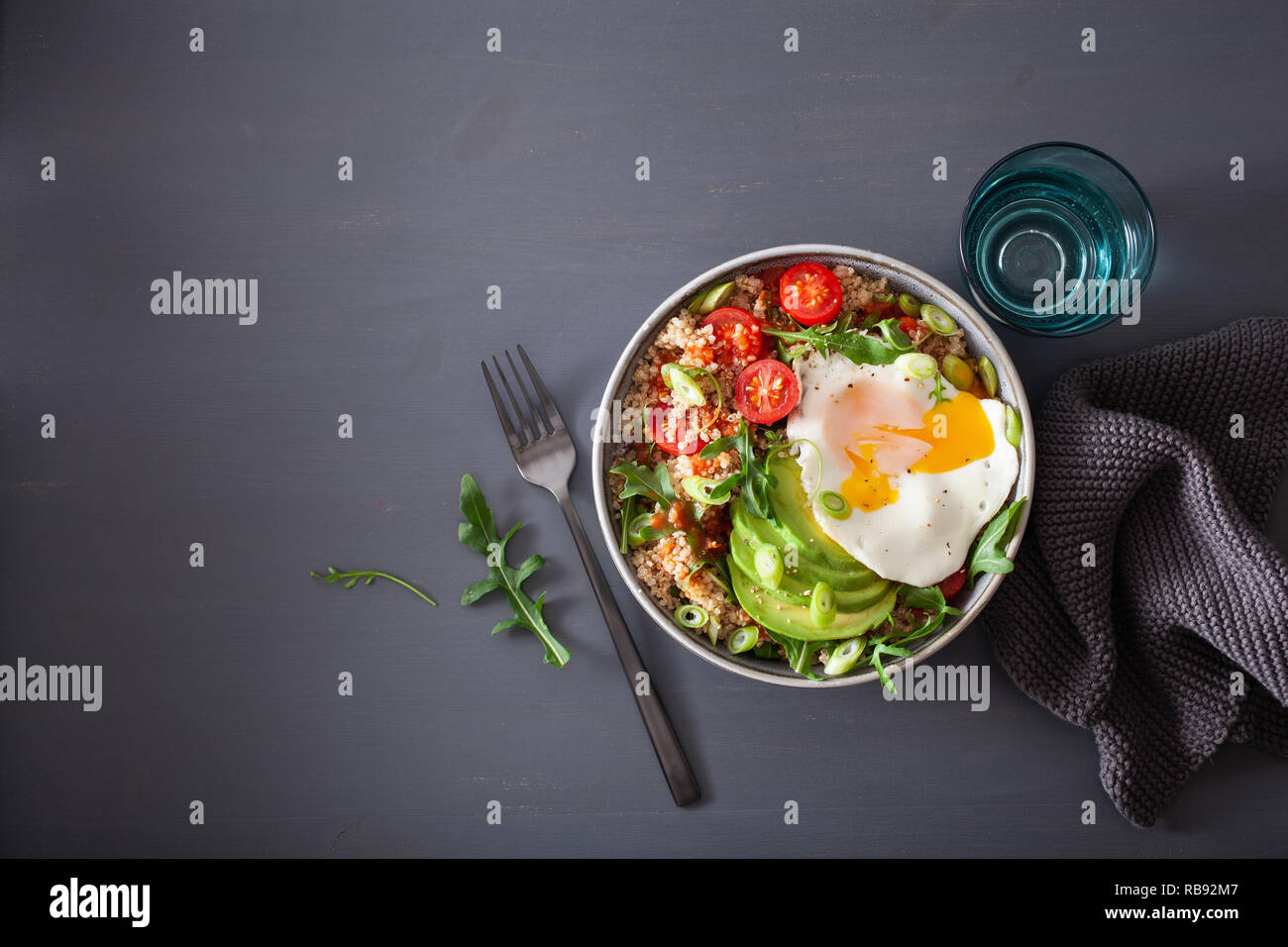 quinoa bowl with fried egg, avocado, tomato, rocket. Healthy vegetarian ...