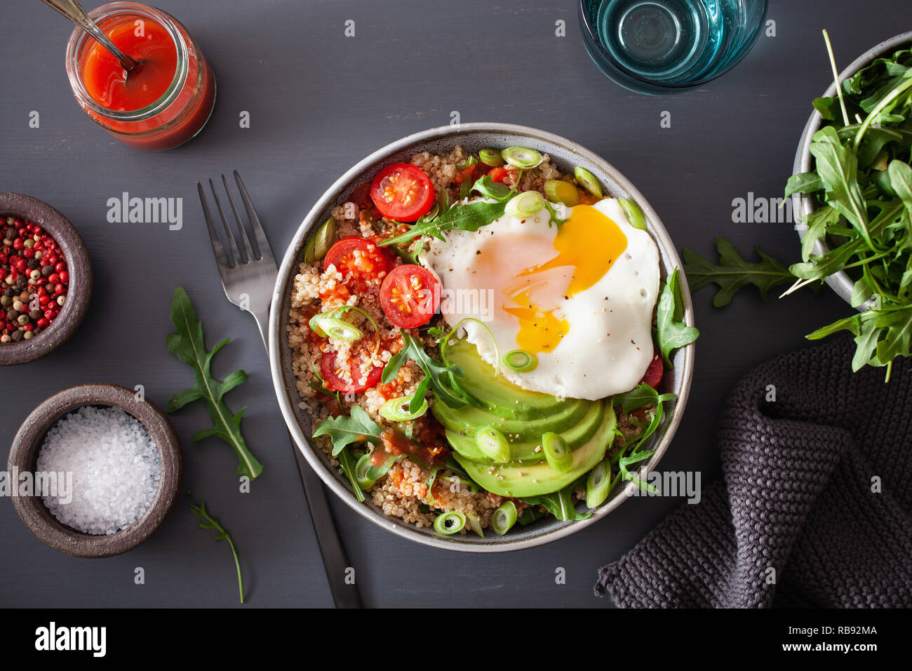 quinoa bowl with fried egg, avocado, tomato, rocket. Healthy vegetarian ...