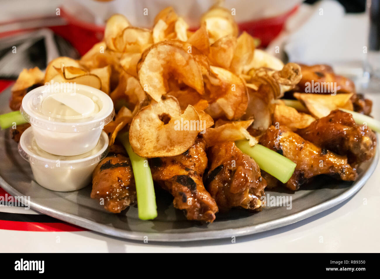 Bar Food: Chicken wing platter from side with curly potatoe chips and ...