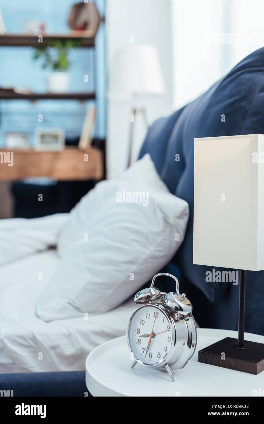 selective focus of alarm clock and lamp in bedroom at home Stock Photo ...