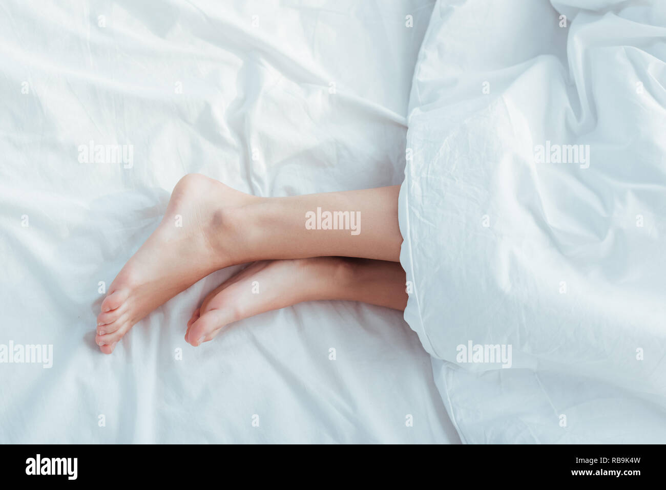 low section of female legs under blanket in bed Stock Photo - Alamy