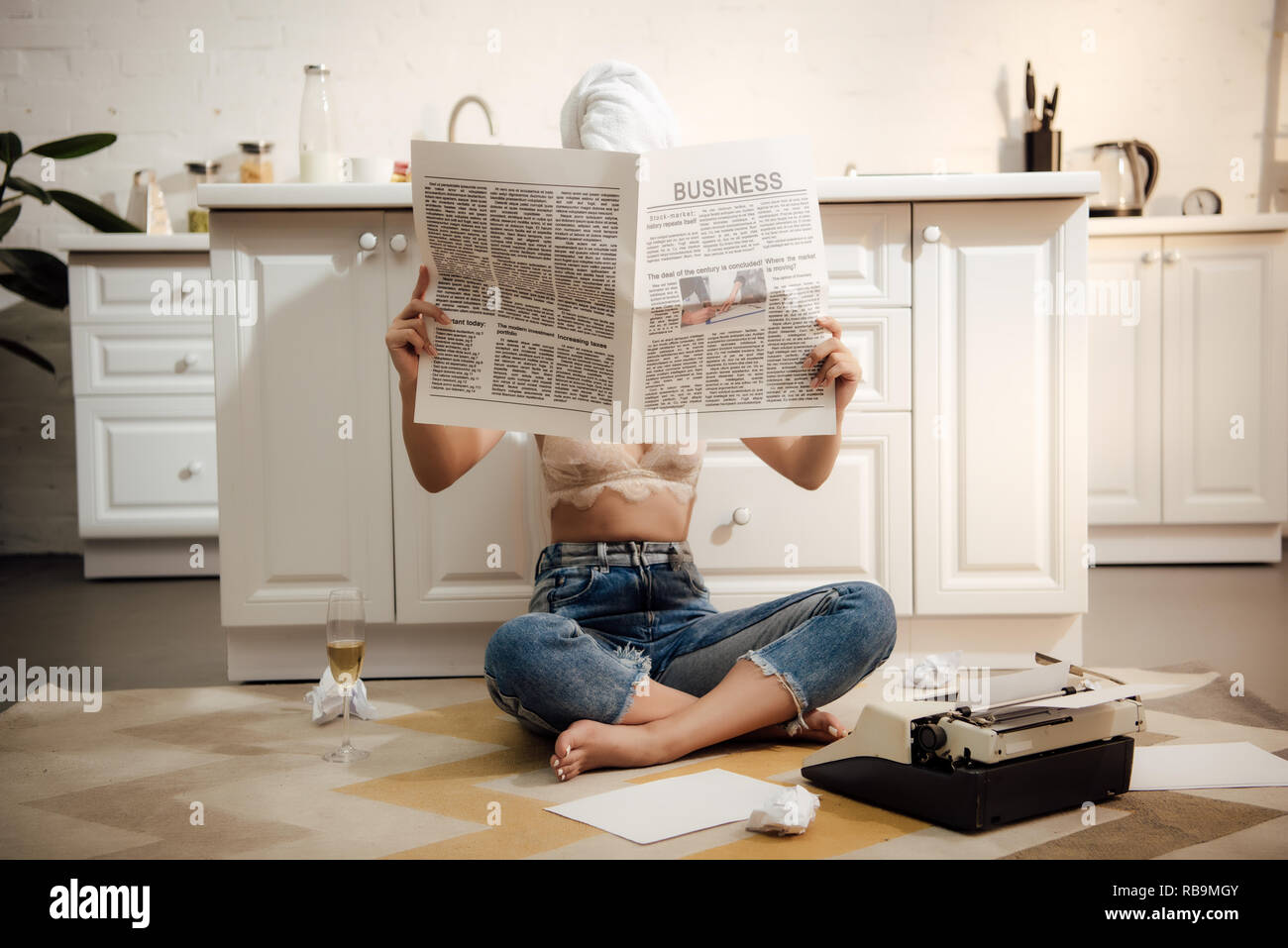 young female author sitting on floor and hiding face behind business ...