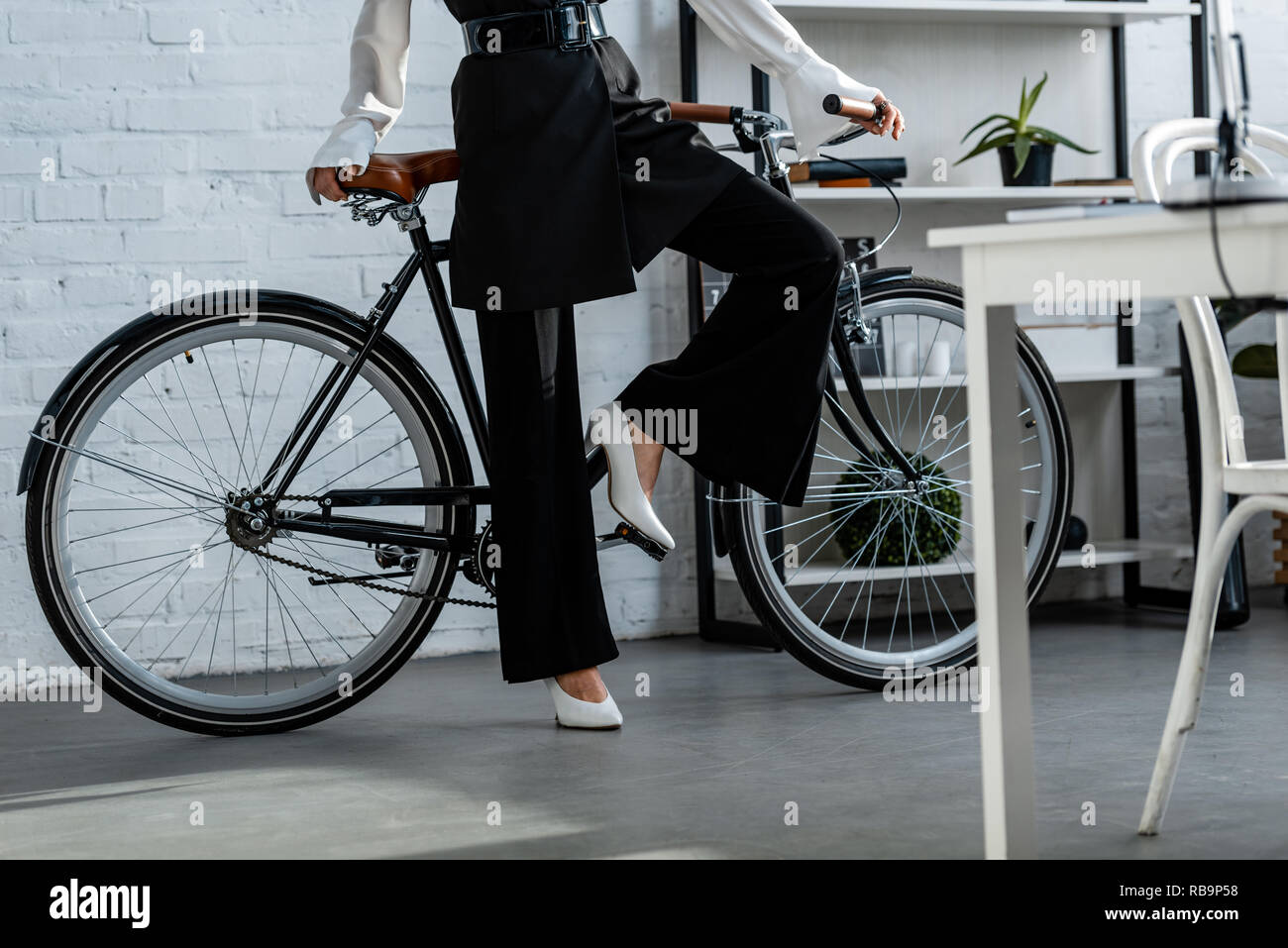 partial view of woman in black formal wear with bicycle Stock Photo - Alamy