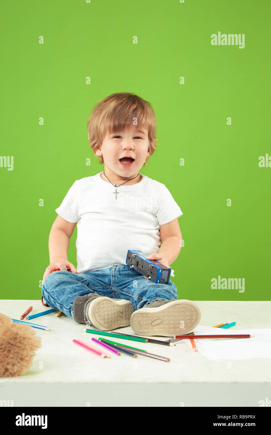 Portrait of happy little boy over green studio background Stock Photo ...