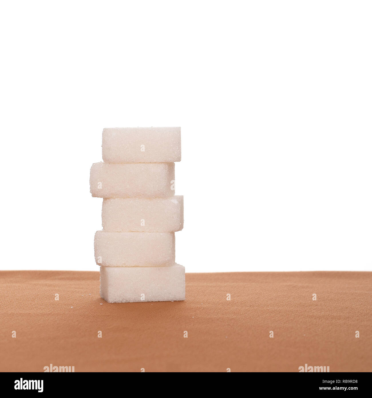 Stack of five sugar cubes on fabric, white background. Healthy eating ...