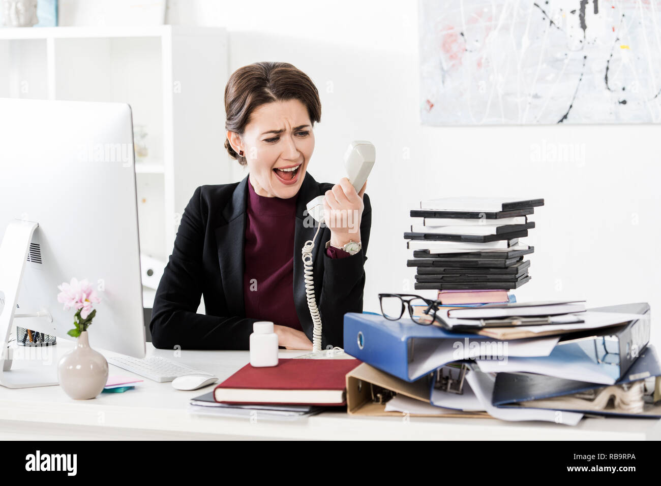 angry attractive businesswoman screaming while talking by stationary ...