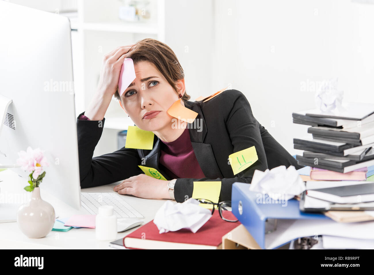 sad attractive businesswoman sitting with stickers on face and clothes ...