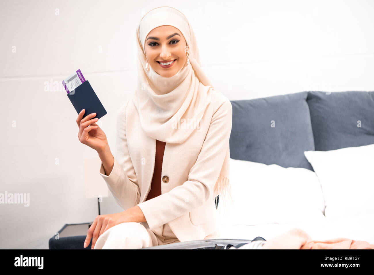 happy young muslim woman holding passport with boarding pass and ...