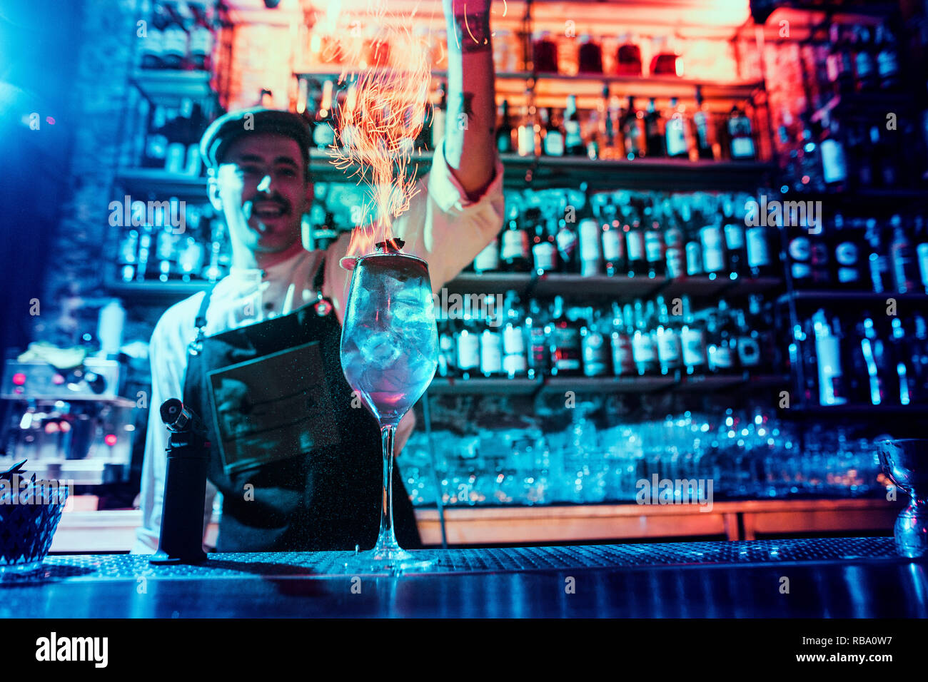 Glass of fiery cocktail on the bar counter against the background of ...