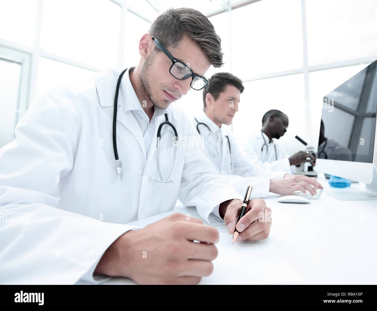 group of scientists sitting at the laboratory table Stock Photo - Alamy