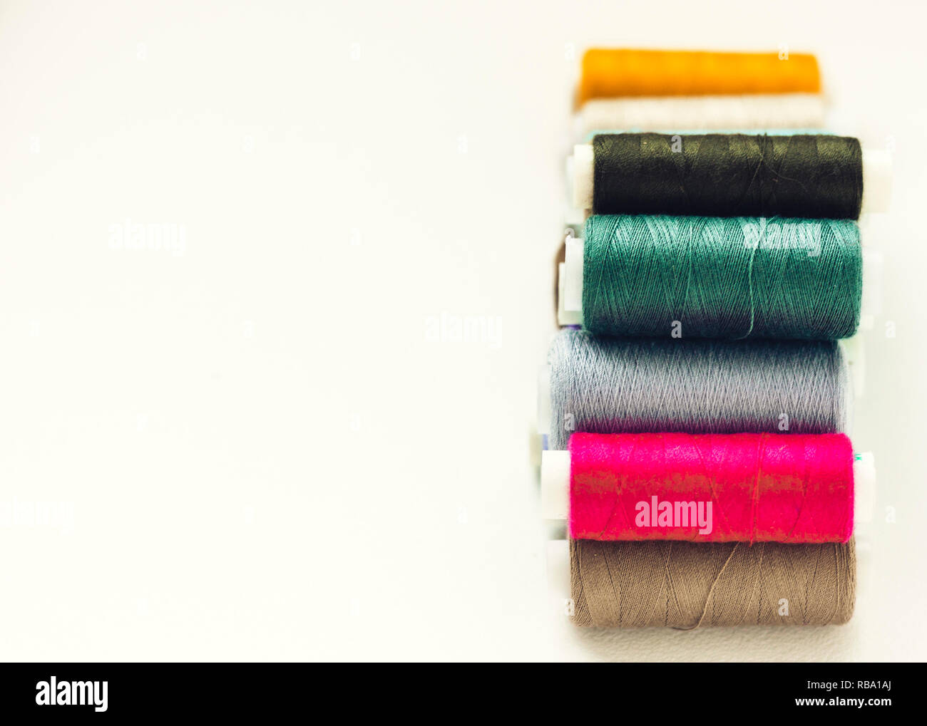 Colored sewing thread coils on white background with copy space for ...