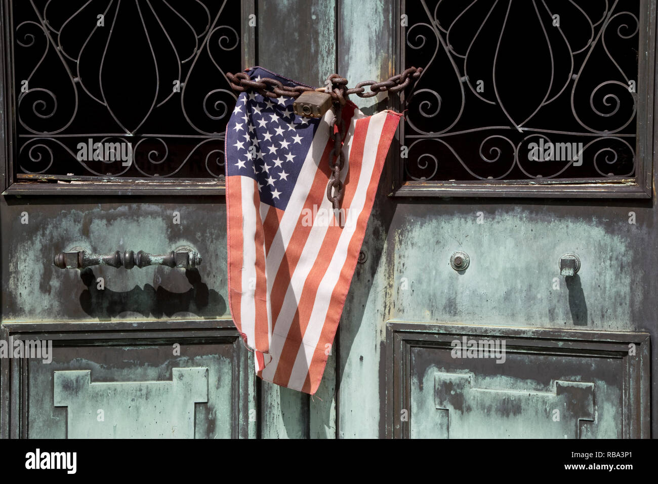 An American flag hangs on chained and padlocked door of a mausoleum ...