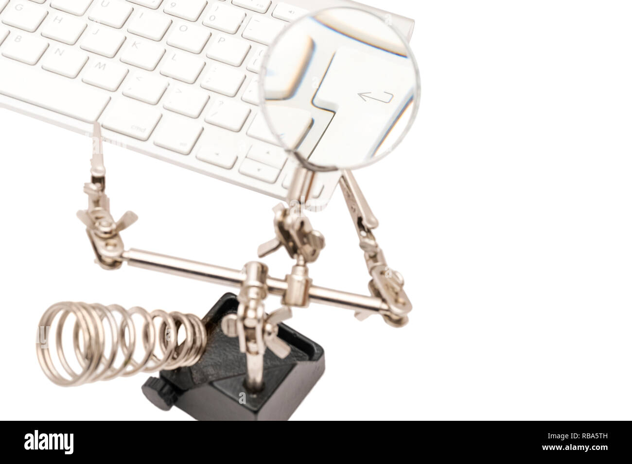 white keyboard with enter key magnified through magnifying glass ...