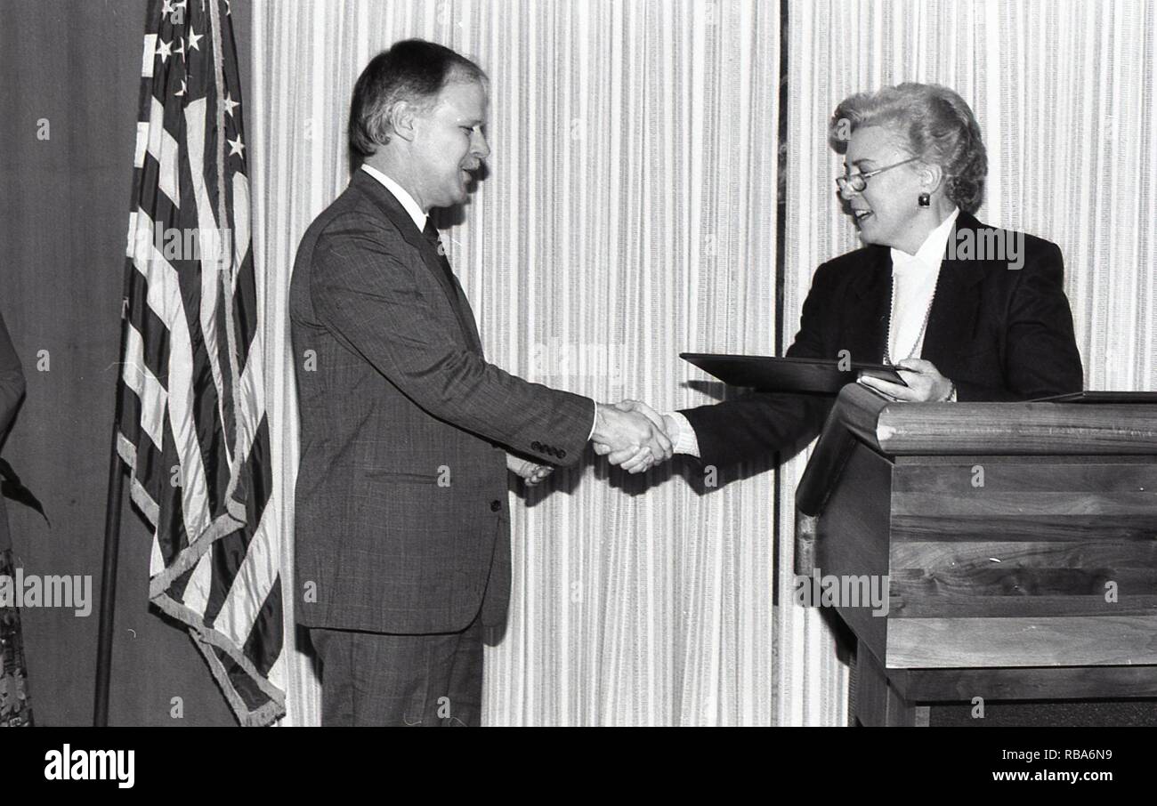 MAN ACCEPTING AWARD AND SHAKING HANDS WITH WOMAN Stock Photo - Alamy
