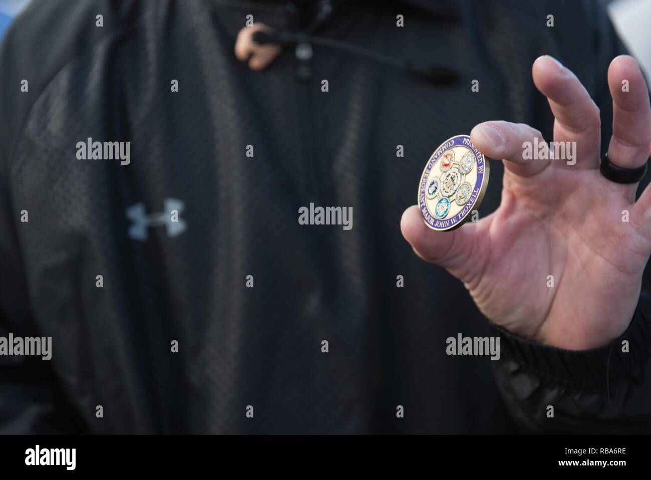 A referee holds up the challenge coin of U.S. Army Command Sgt. Maj ...