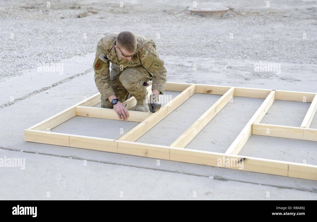 U.S. Army Capt. Grant Cuprak measures a frame that is part of a modular ...