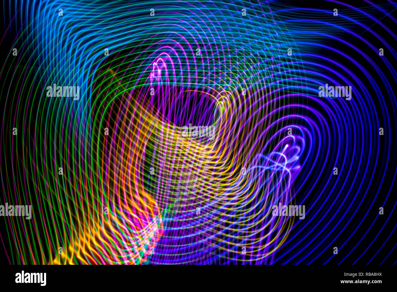 Abstract rainbow neon glowing crossing lines pattern. Dark background of colorful neon glowing ...