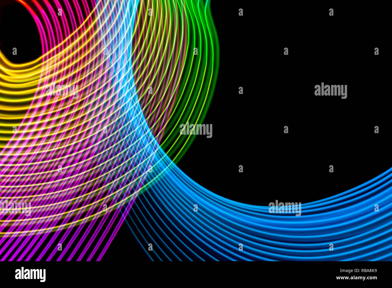 Abstract rainbow neon glowing crossing lines pattern. Dark background of colorful neon glowing ...