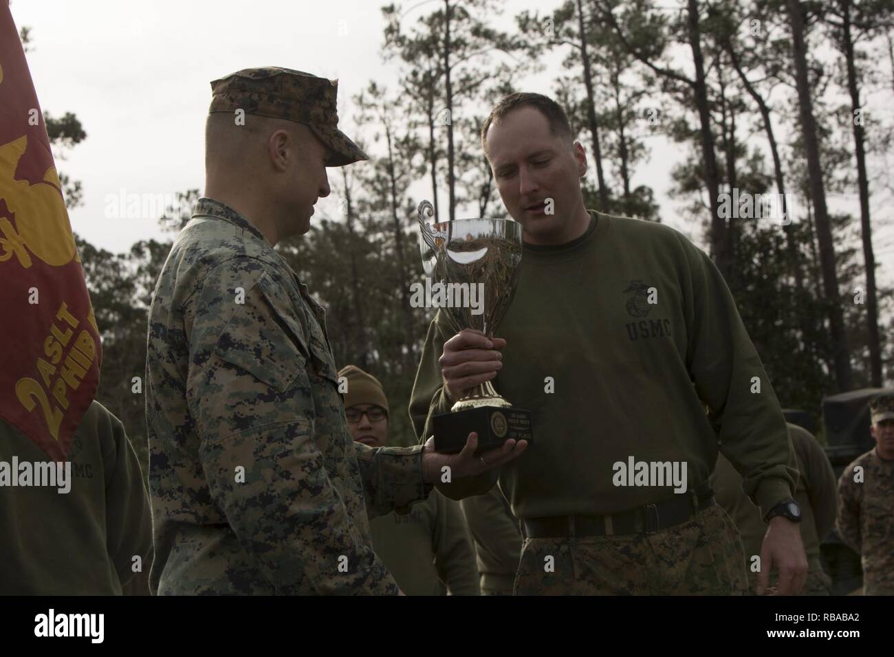 Lt. Col. David W. Bass (left) presents a trophy to Capt. Michael ...