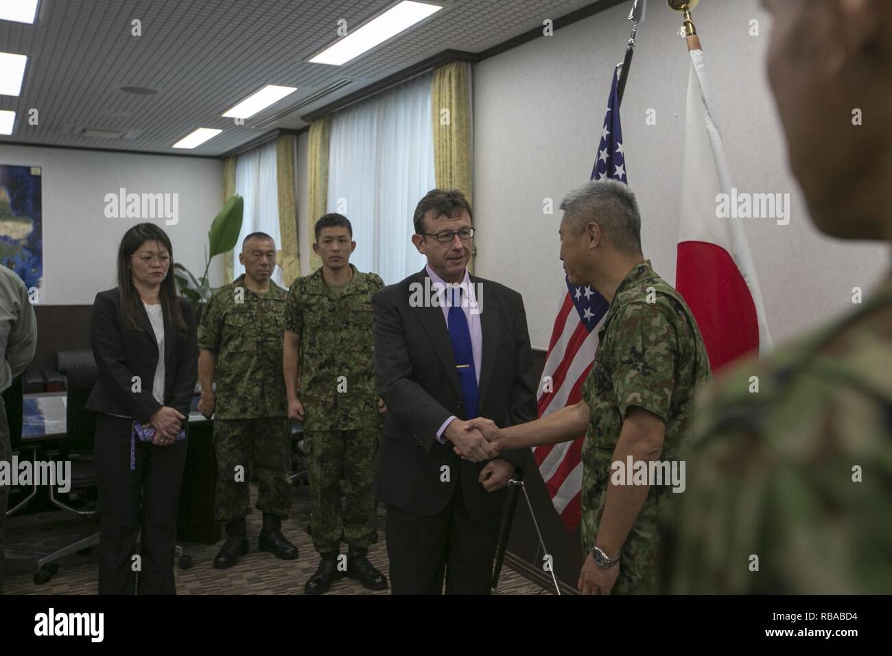 Maj. Gen. Tomofusa Harada, right, shakes hands with Mr. John Peters ...