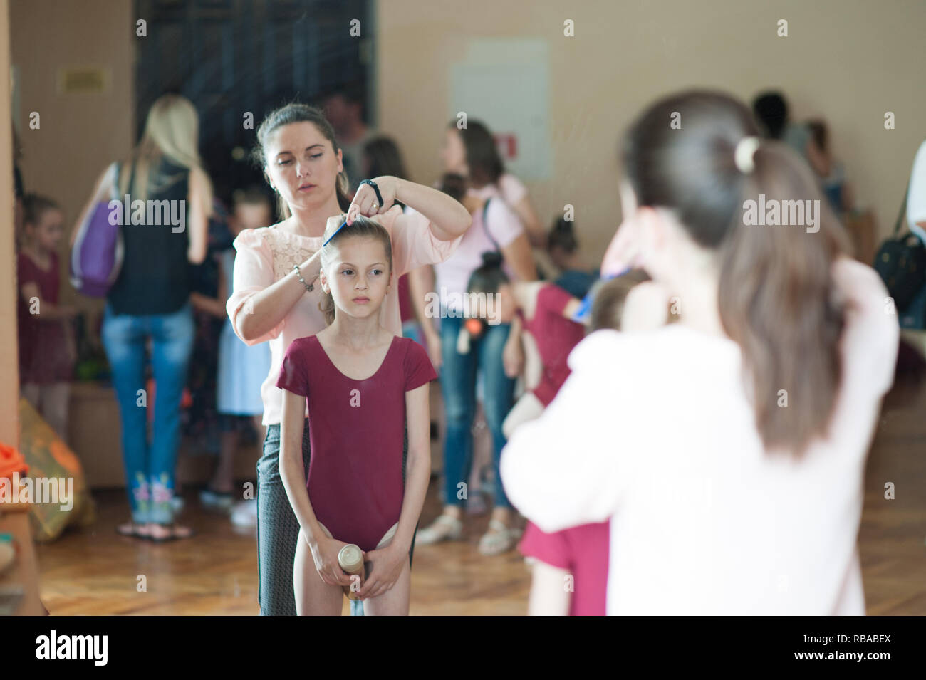 young caucasian mother corrects her ballerina dancer little slim ...