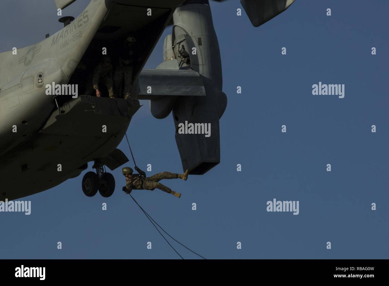 A Marine with III Marine Expeditionary Force fast ropes from an MV-22B ...