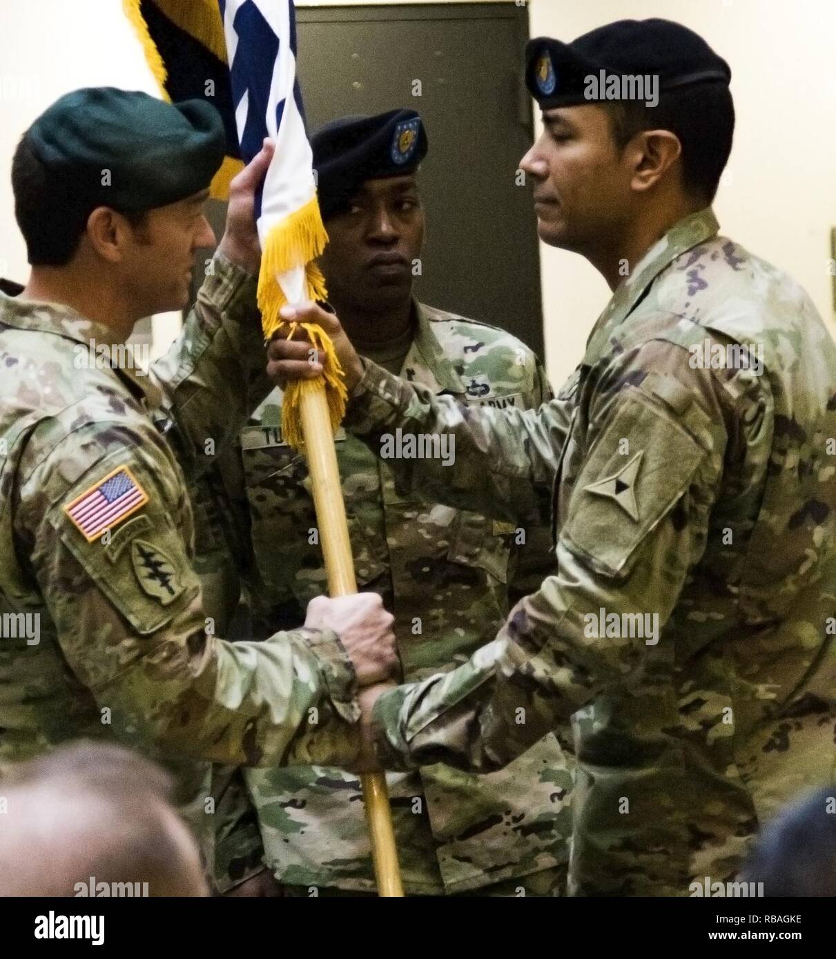 Command Sgt. Maj. Louis De Leon (right) passes the battalion guidon to ...