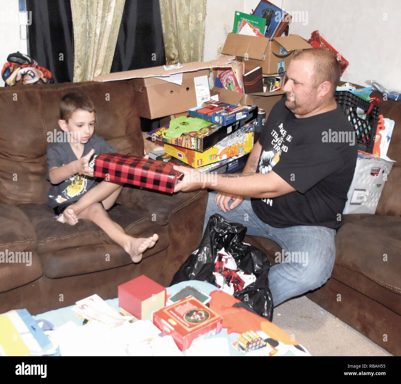Christopher Quibodeaux hands his son, 8-year-old Drake, a present ...