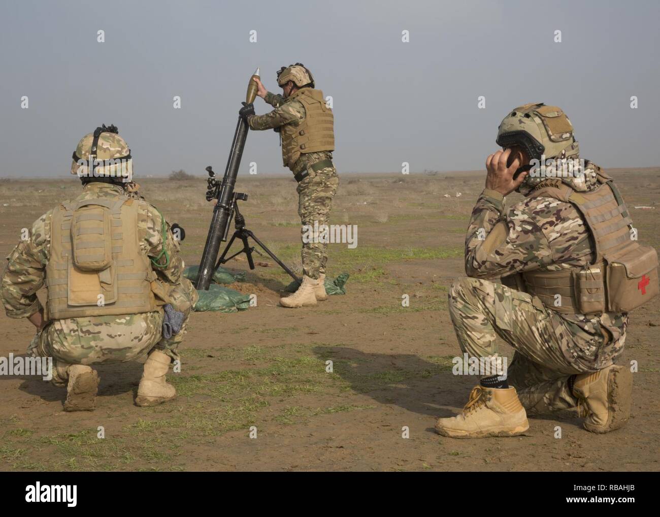 An Iraqi soldier prepares to drop a mortar down a mortar tube during a ...