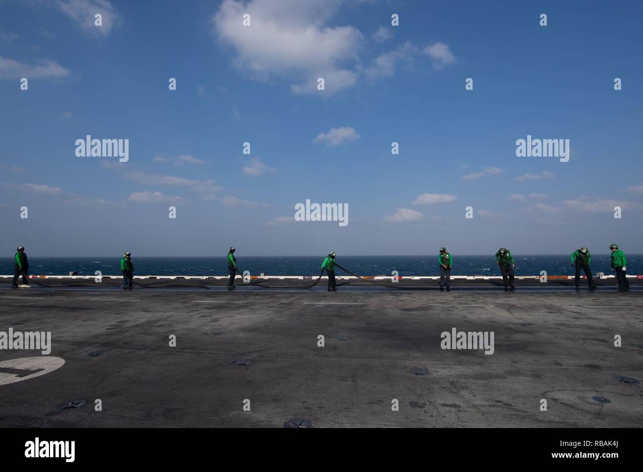 U.S. Sailors place a slot seal on a steam-powered catapult during ...