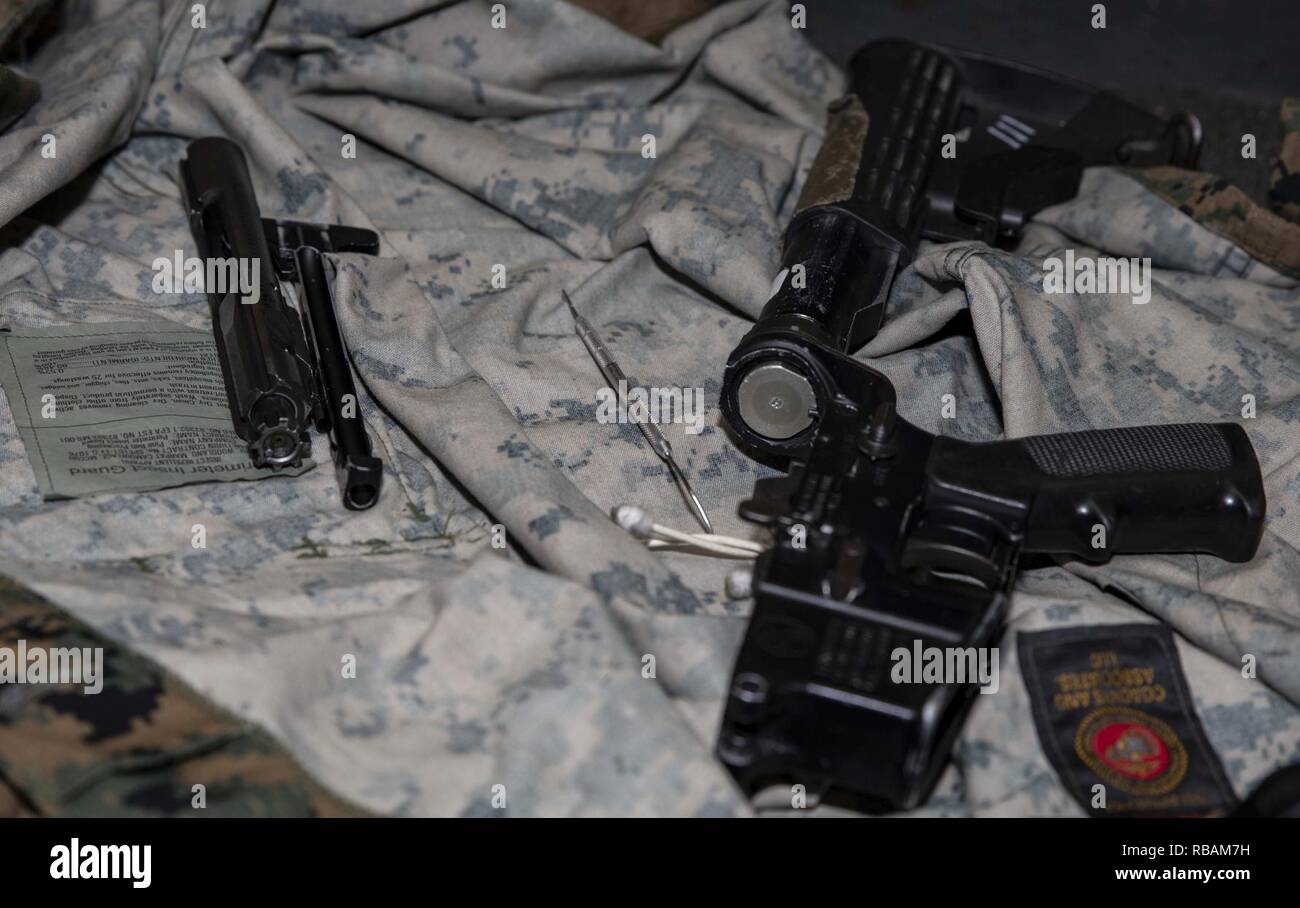 An M4 Carbine lays disassembled while infantry Marines with the 22nd ...