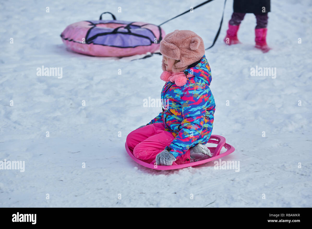 little girl riding on snow slides in winter time Stock Photo - Alamy