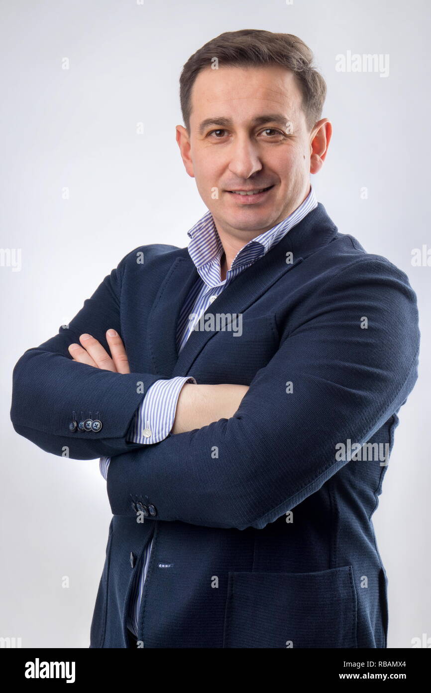 Portrait of a handsome young middle aged CEO in a blue suit and smiling ...