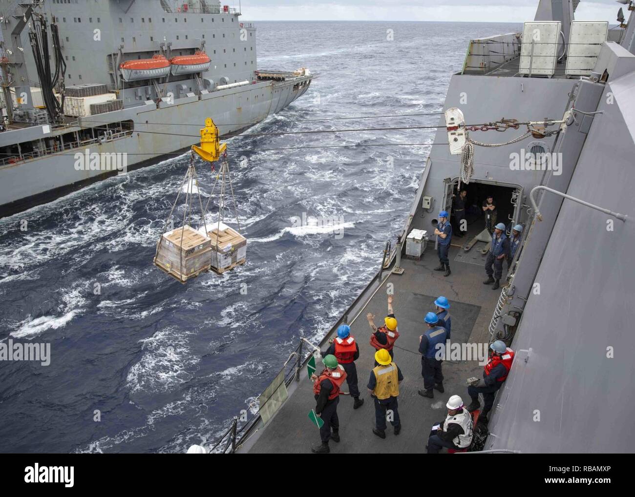 Sailors aboard the USS Arlington (LPD 24) receive supplies from the ...