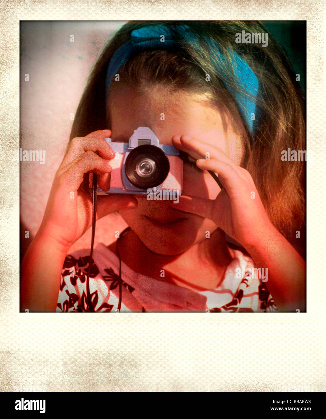 Vintage polaroid photo of little girl, photographing with a camera toy ...