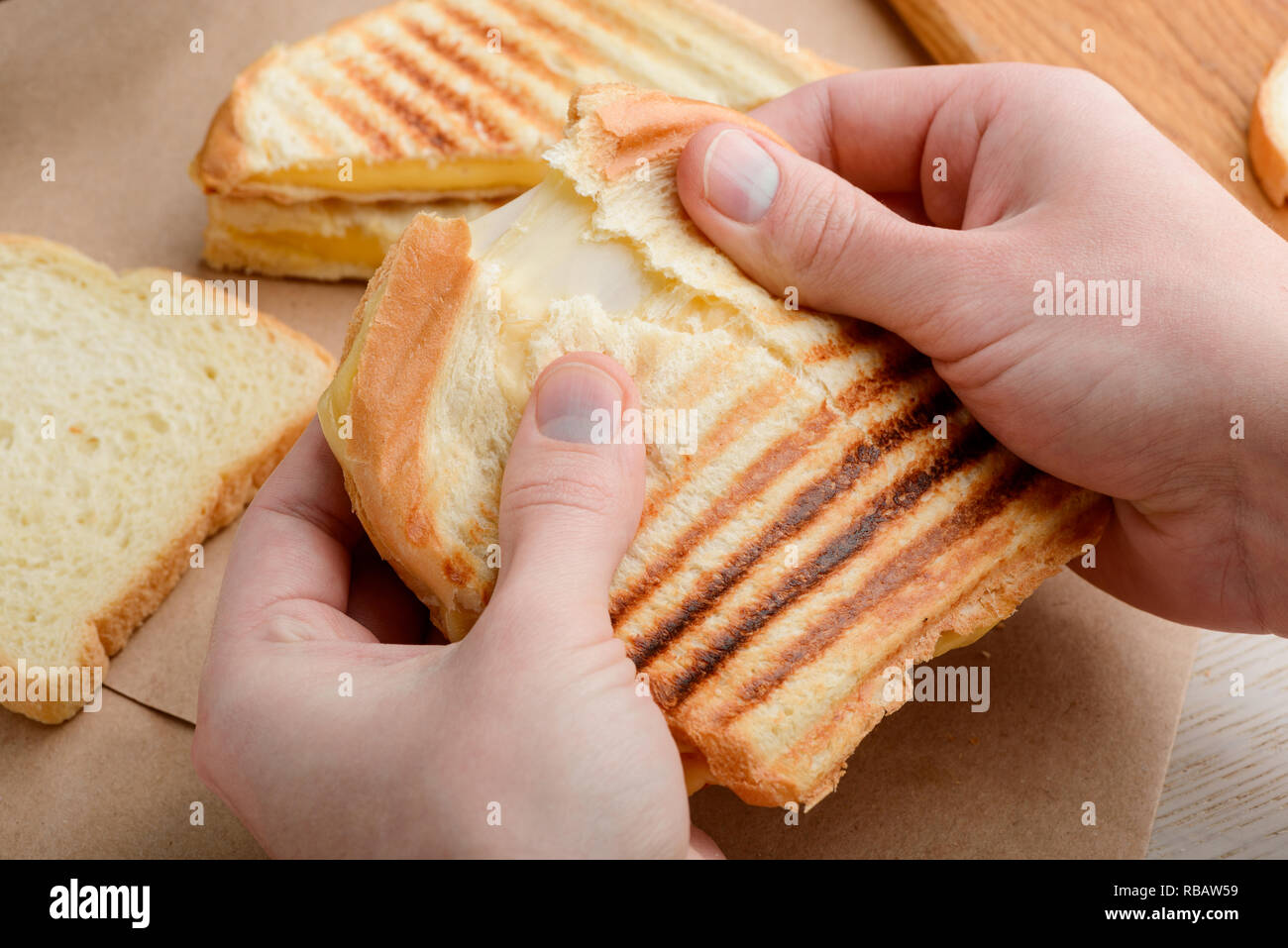Man tearing a sandwich apart Stock Photo - Alamy