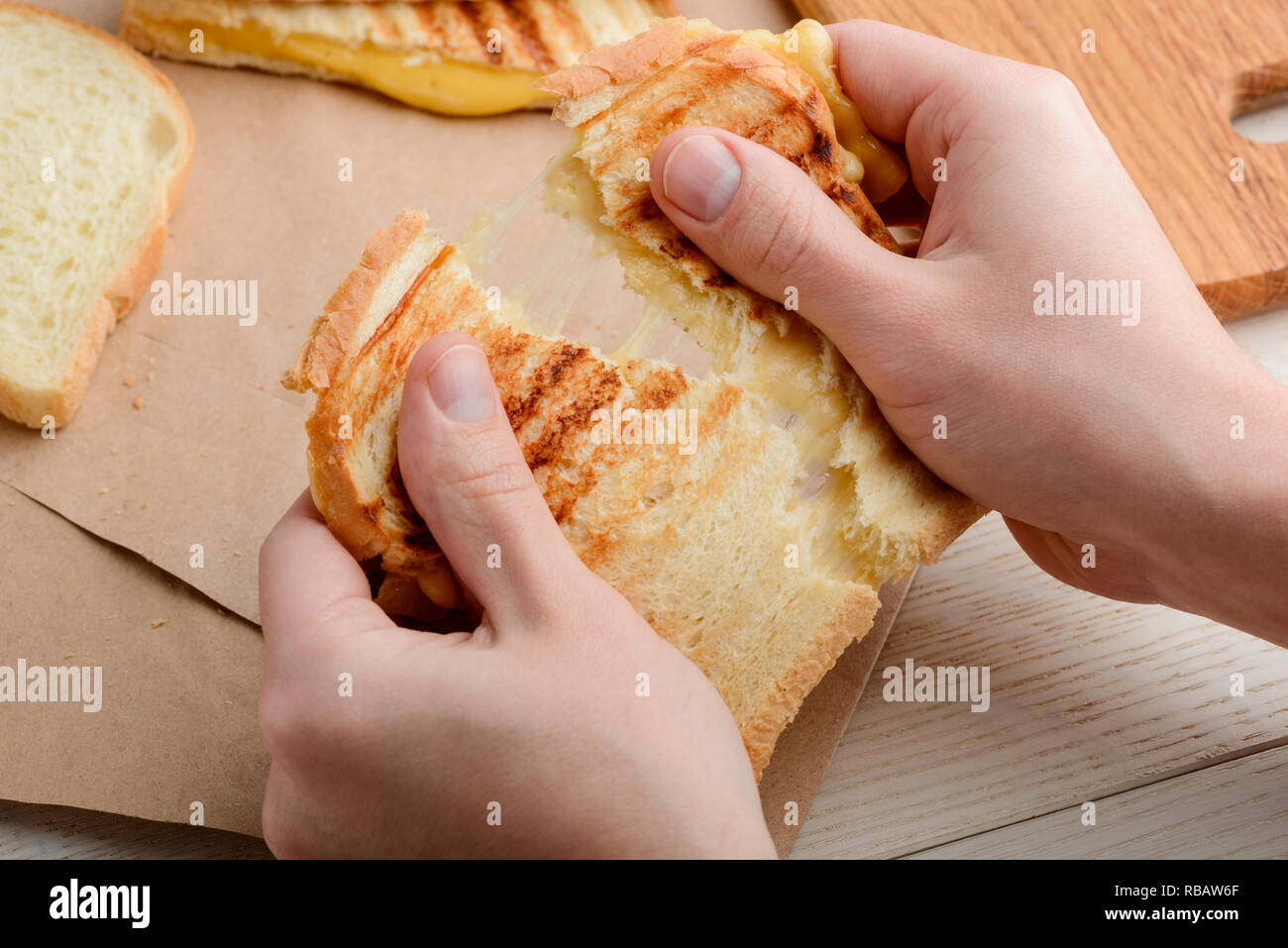 Man tearing a sandwich Stock Photo - Alamy