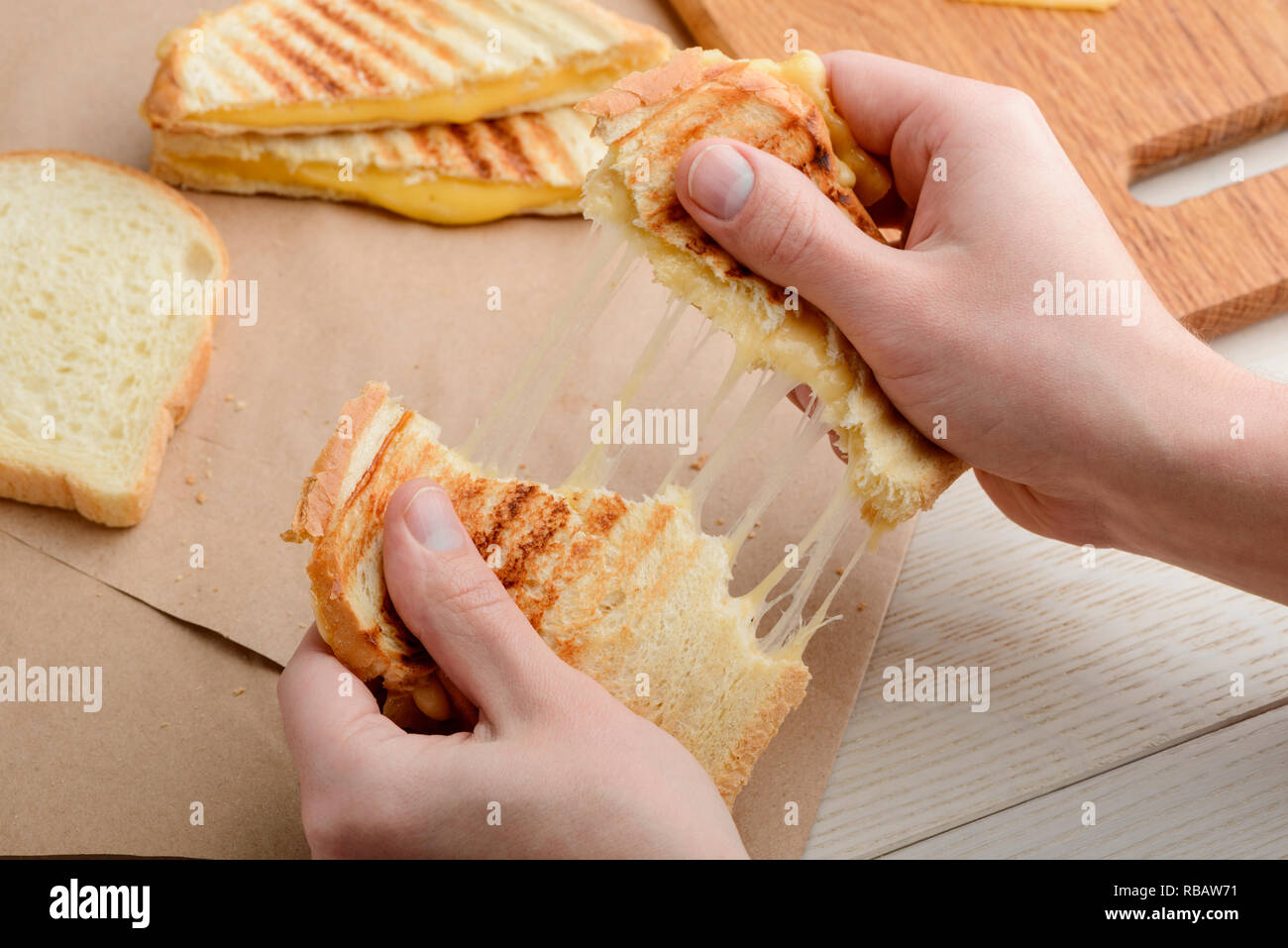 Hands tearing a sandwich Stock Photo - Alamy