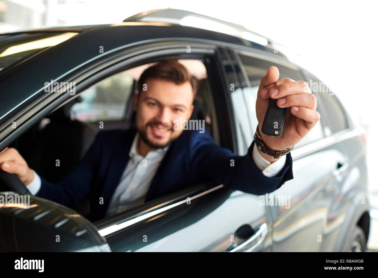 Male driver smiling holds the keys to the car Stock Photo - Alamy